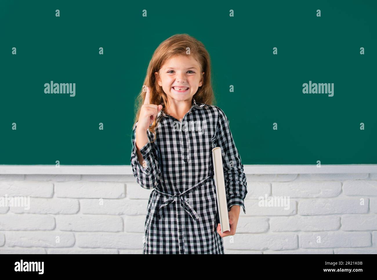 School girl with pointing finger studying math on lesson in classroom ...