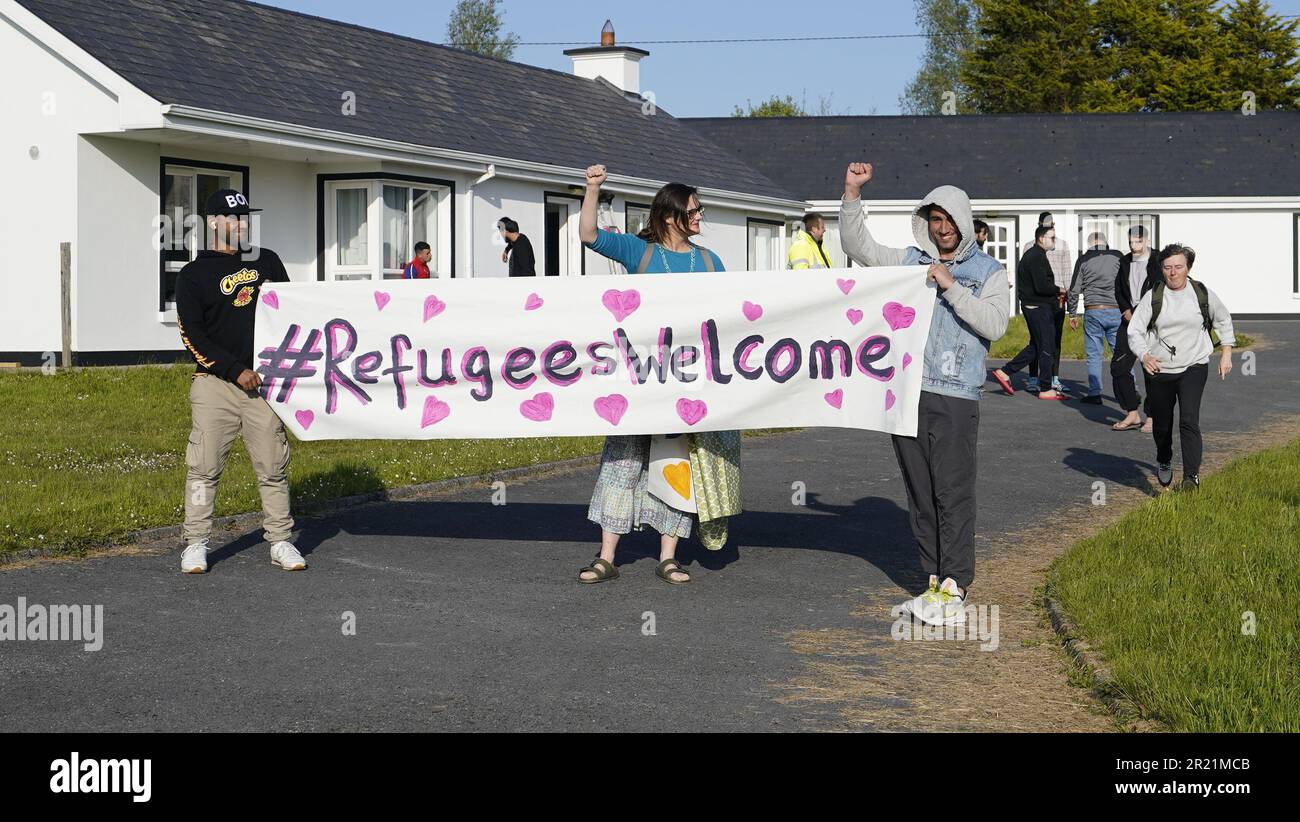 Local residents with asylum seekers hold up a banner supporting ...