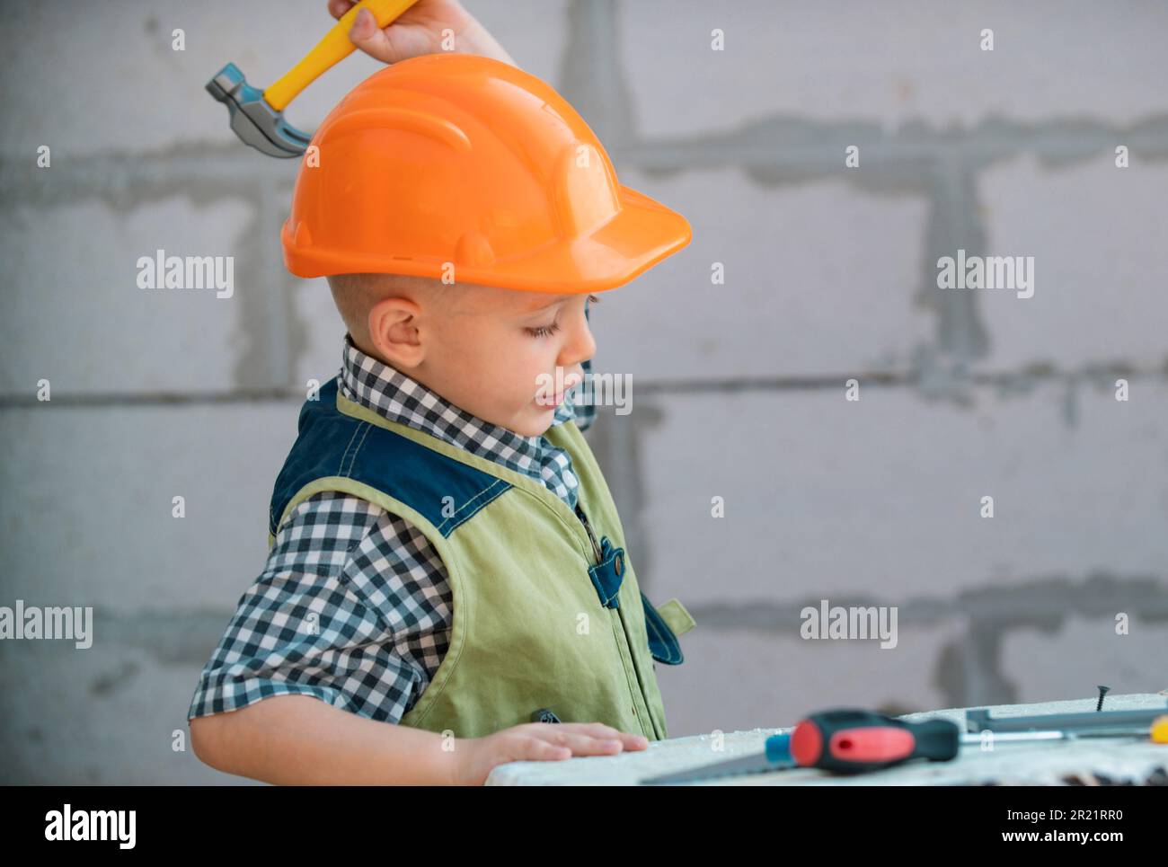 Portrait of little builder in hardhats with instruments for renovation ...