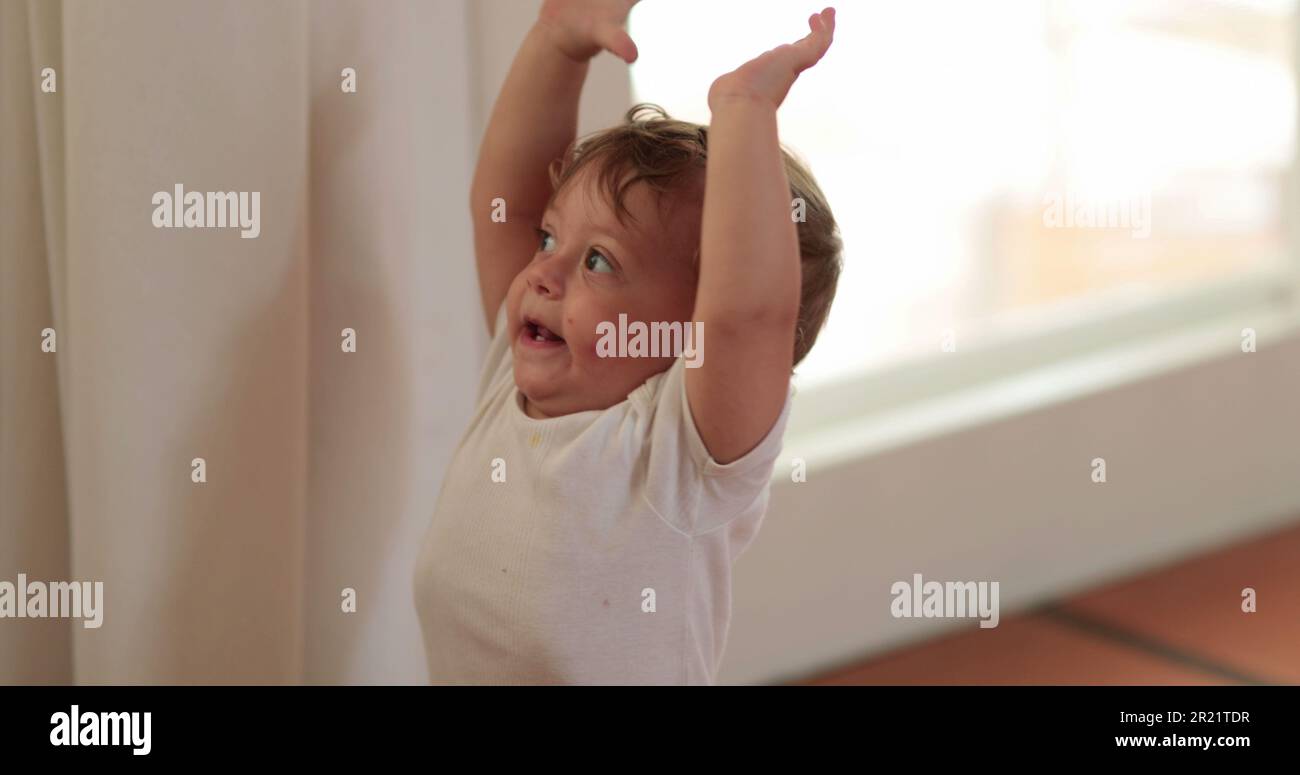 Cute baby cheering hands up in the air celebrating Stock Photo - Alamy
