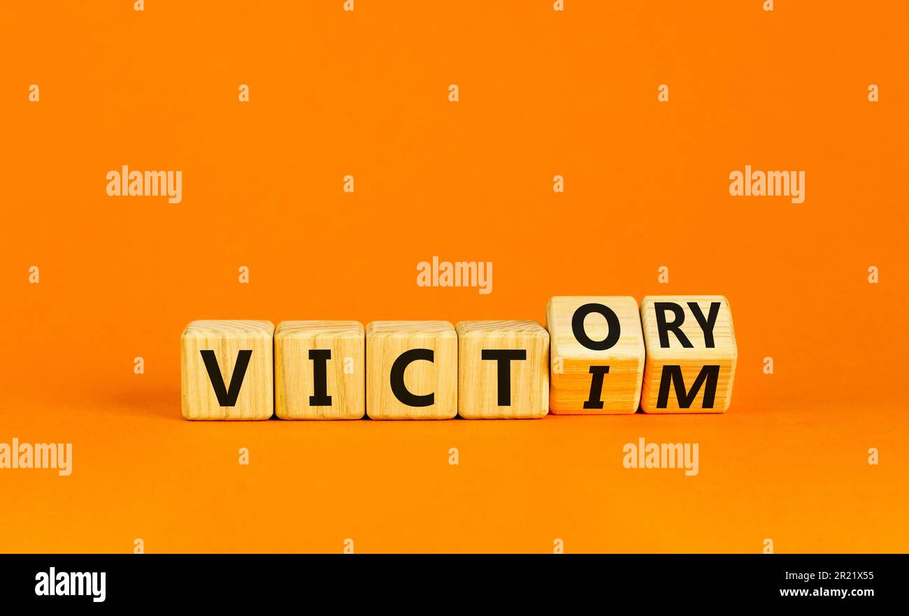 From victim to victory symbol. Businessman turns wooden cubes and ...