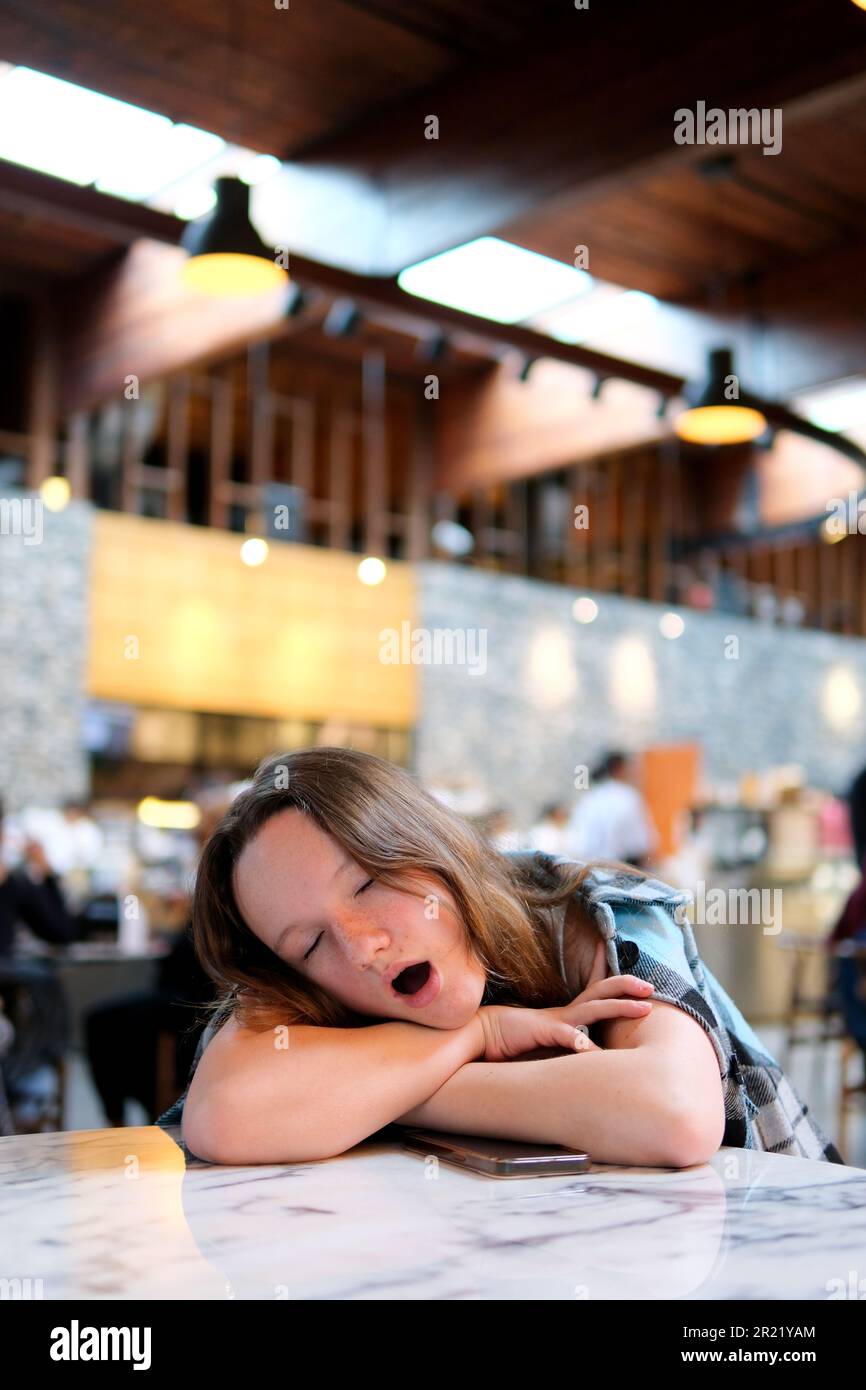 bored yawn young teenage girl falls asleep in cafe expect a friend lean ...