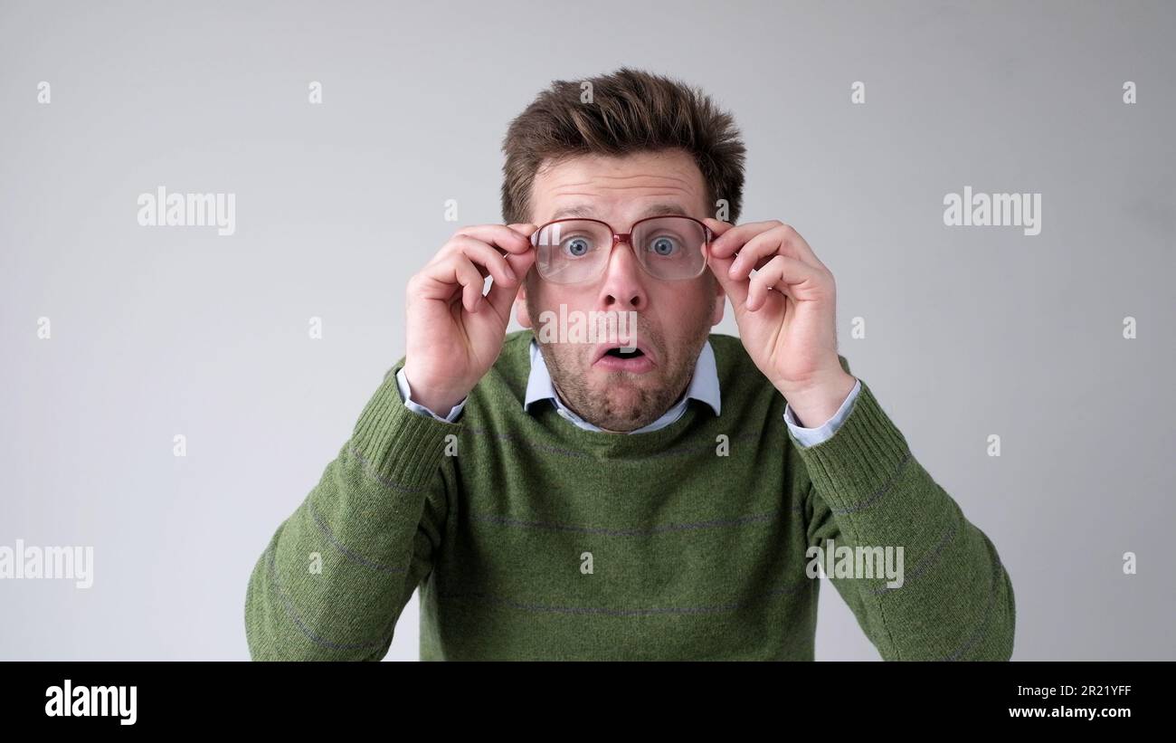 The European young man, in shock, covers his mouth with his hands ...