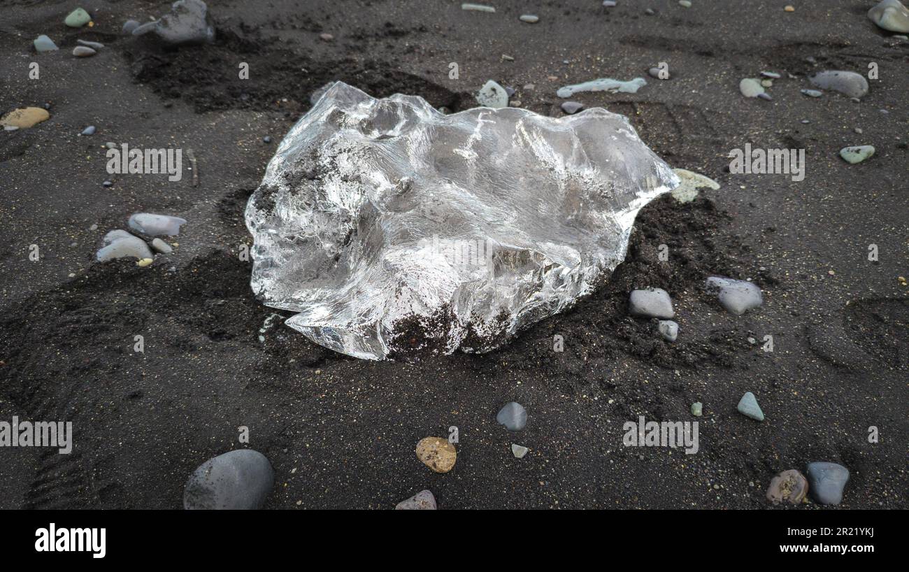 The chunks of ice sitting in the sand at the Diamond beach Stock Photo ...