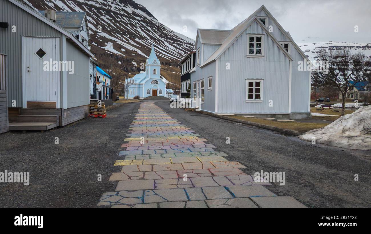 A winter street scene with a brick pathway lined with buildings and ...
