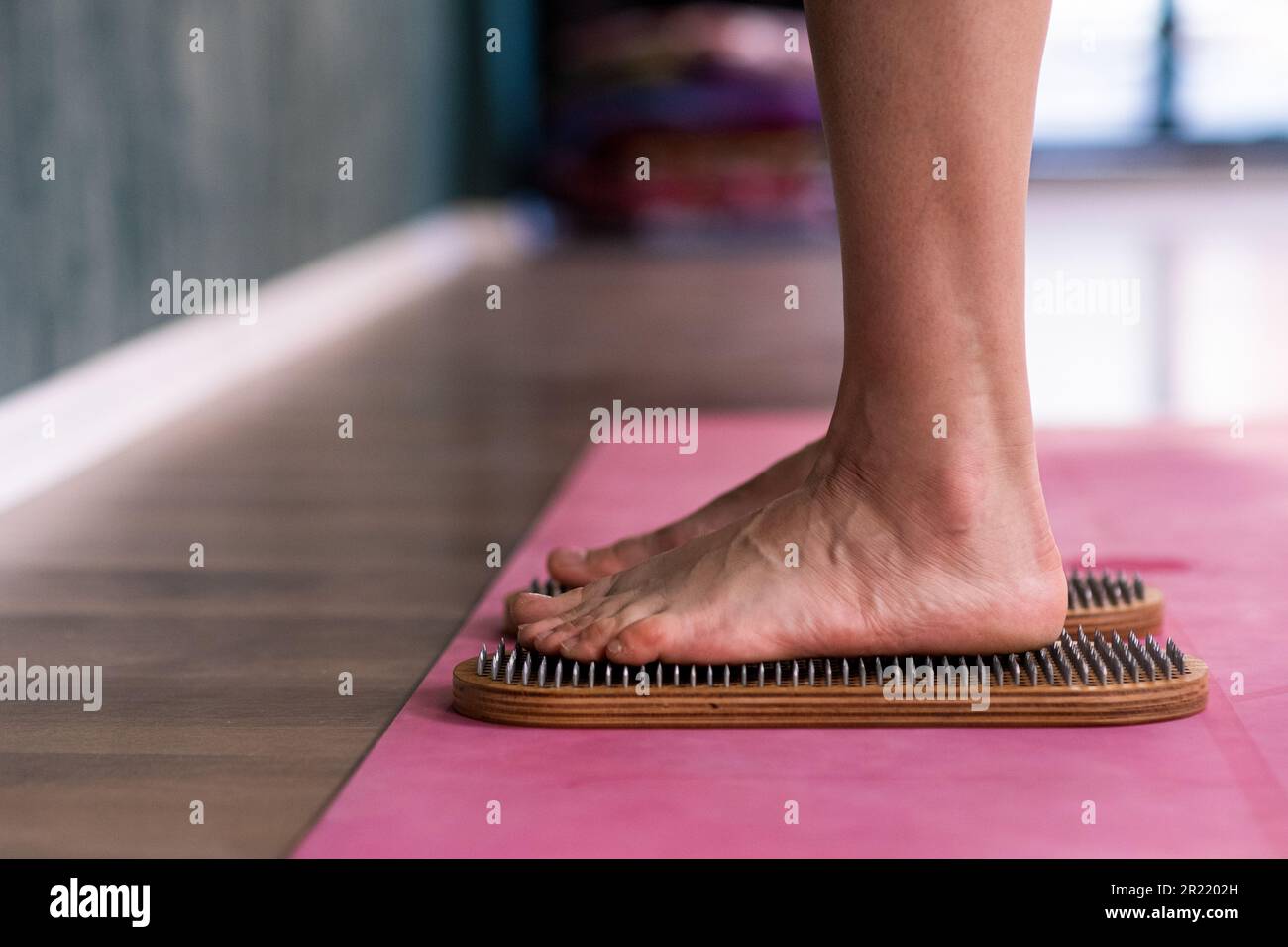 Standing barefoot woman doing nail reflexotherapy at professional yoga ...