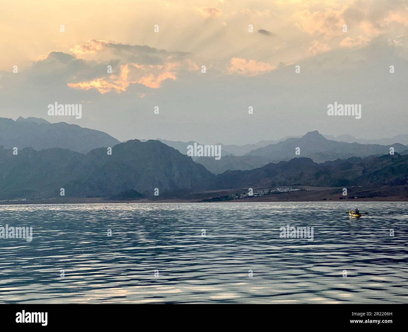 A Lone Figure In A Small Boat Is Peacefully Rowing Across The Misty