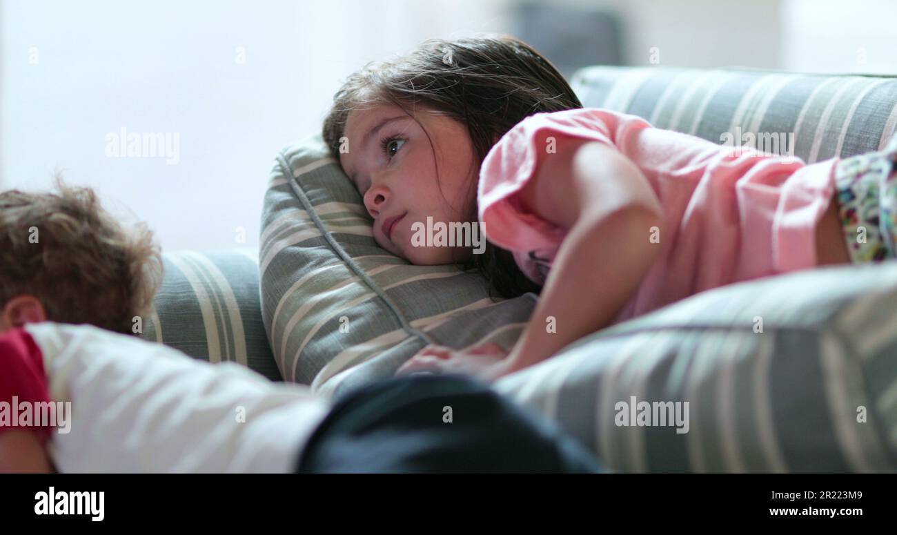 Kids laid on sofa watching movie at night. Children lying on couch ...