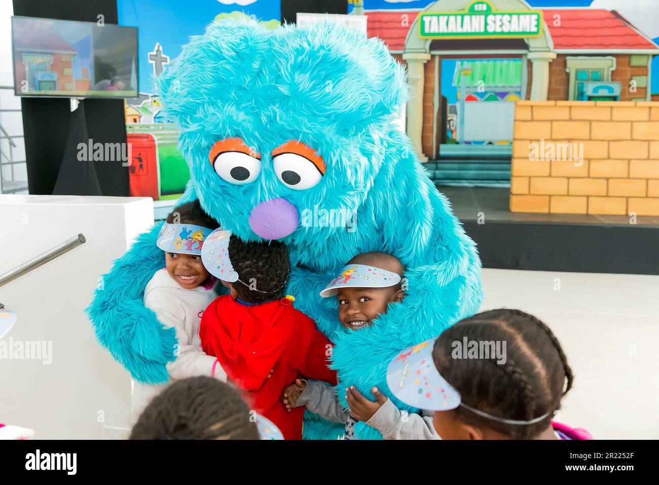 A large Sesame Street style character performing for African children ...
