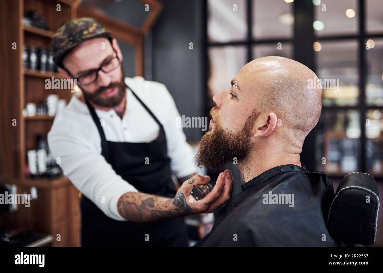 Respect the beard. a handsome young barber trimming and lining up a ...