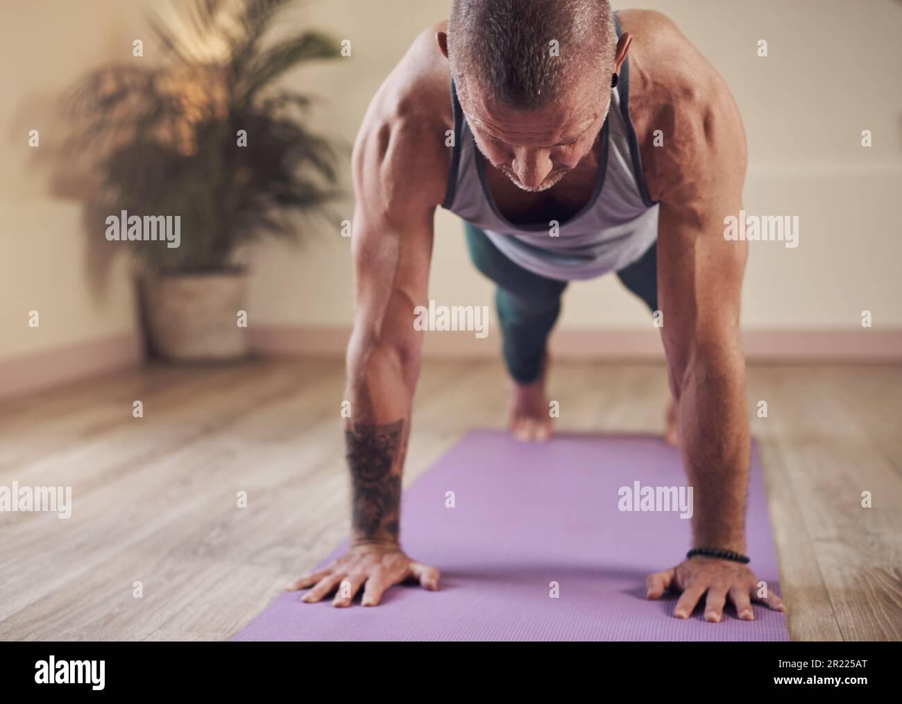 Feel the burn. a handsome young man holding a high plank pose during an ...