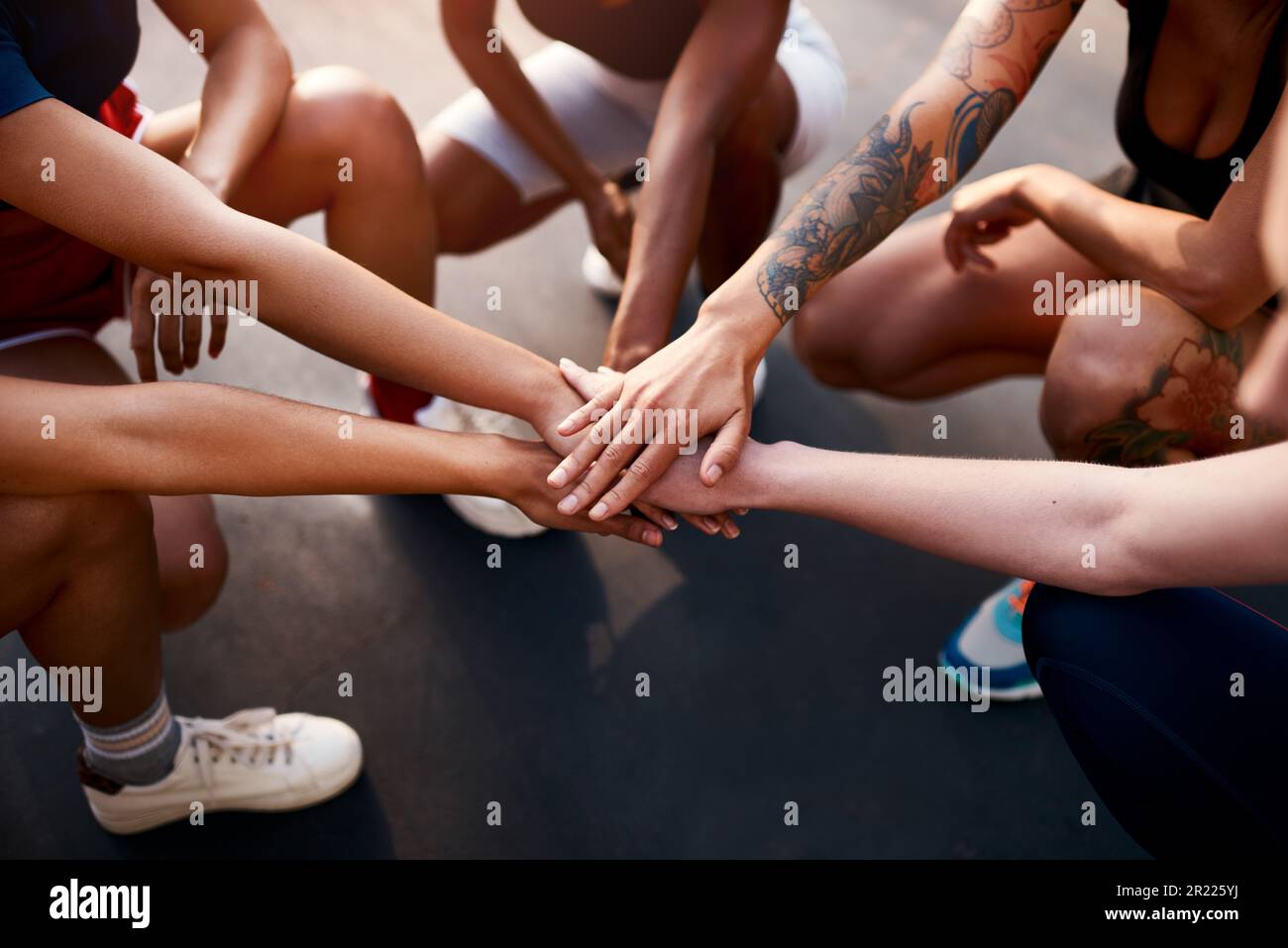 Promoting team spirit. an unrecognizable group of sportswomen piling ...