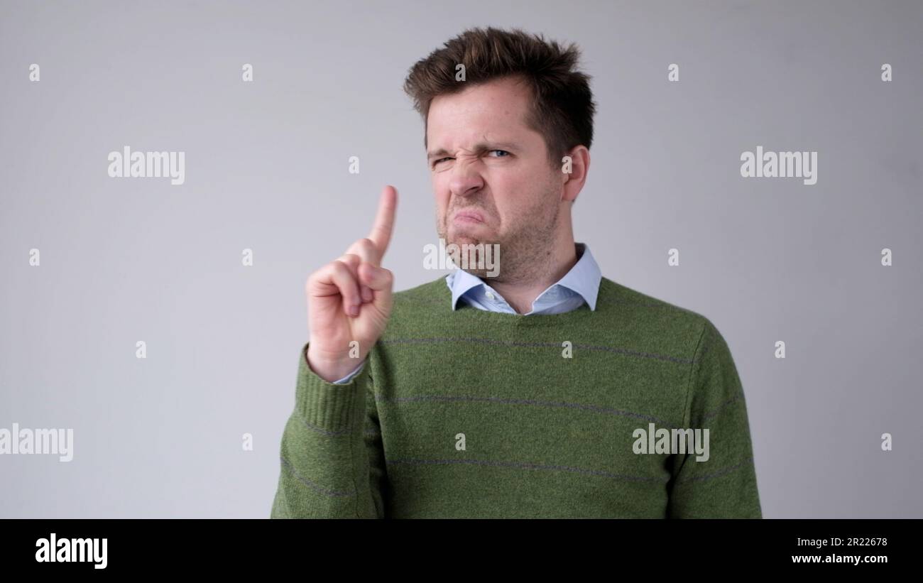 European young man shakes his head in disagreement and says no ...