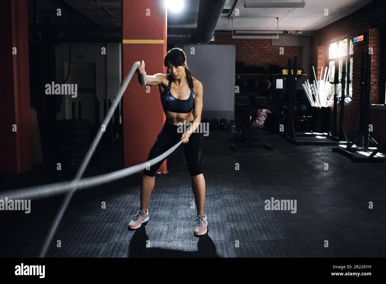 Body under construction. a young woman doing heavy rope training at the ...