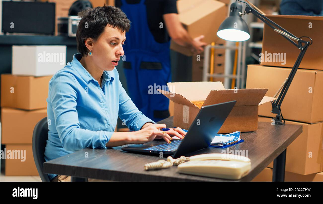 Business owner analyzing boxes with merchandise to ship order to ...