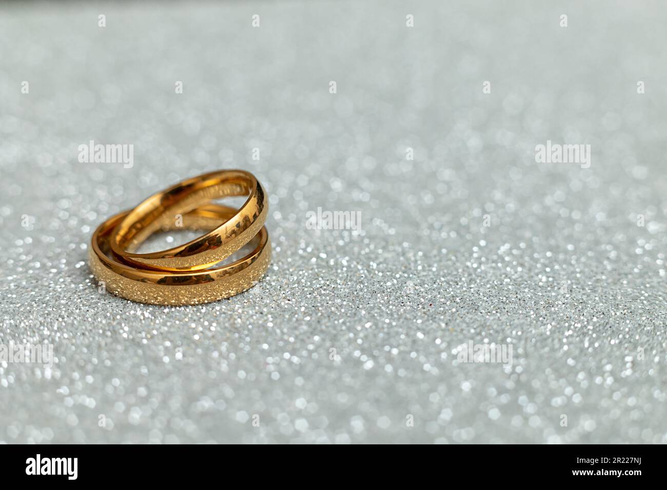 Will you marry me. Two golden wedding rings on silver glitter ...