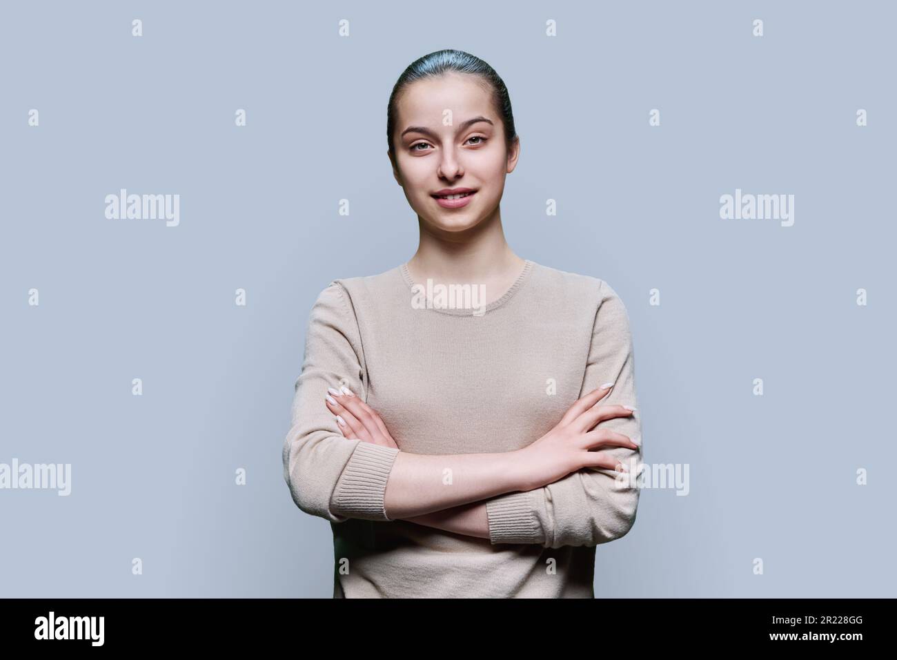 Portrait of smiling high school student girl on grey background Stock ...