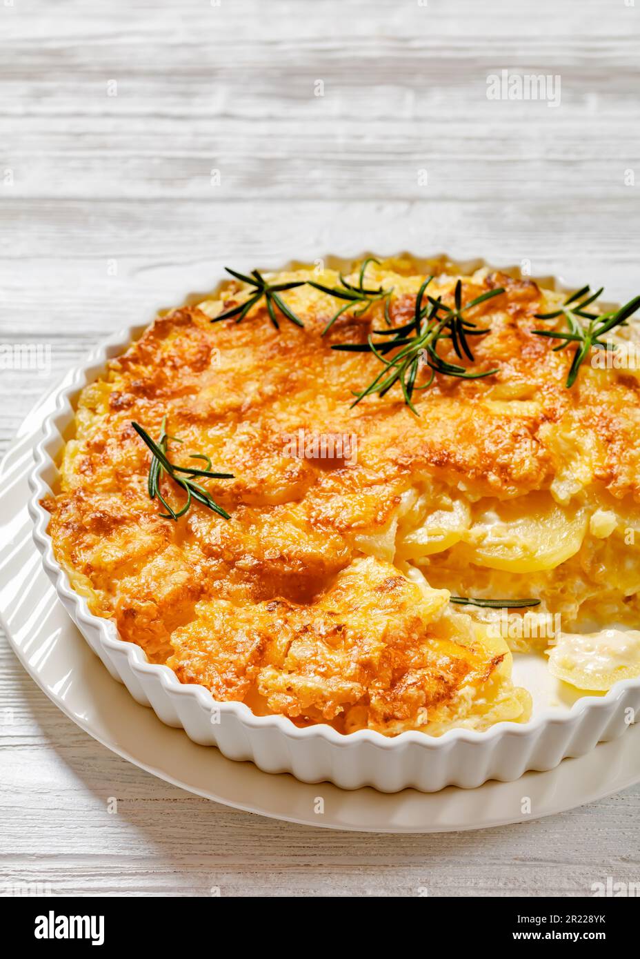 easy cheesy potato bake or potato casserole in white baking dish on ...