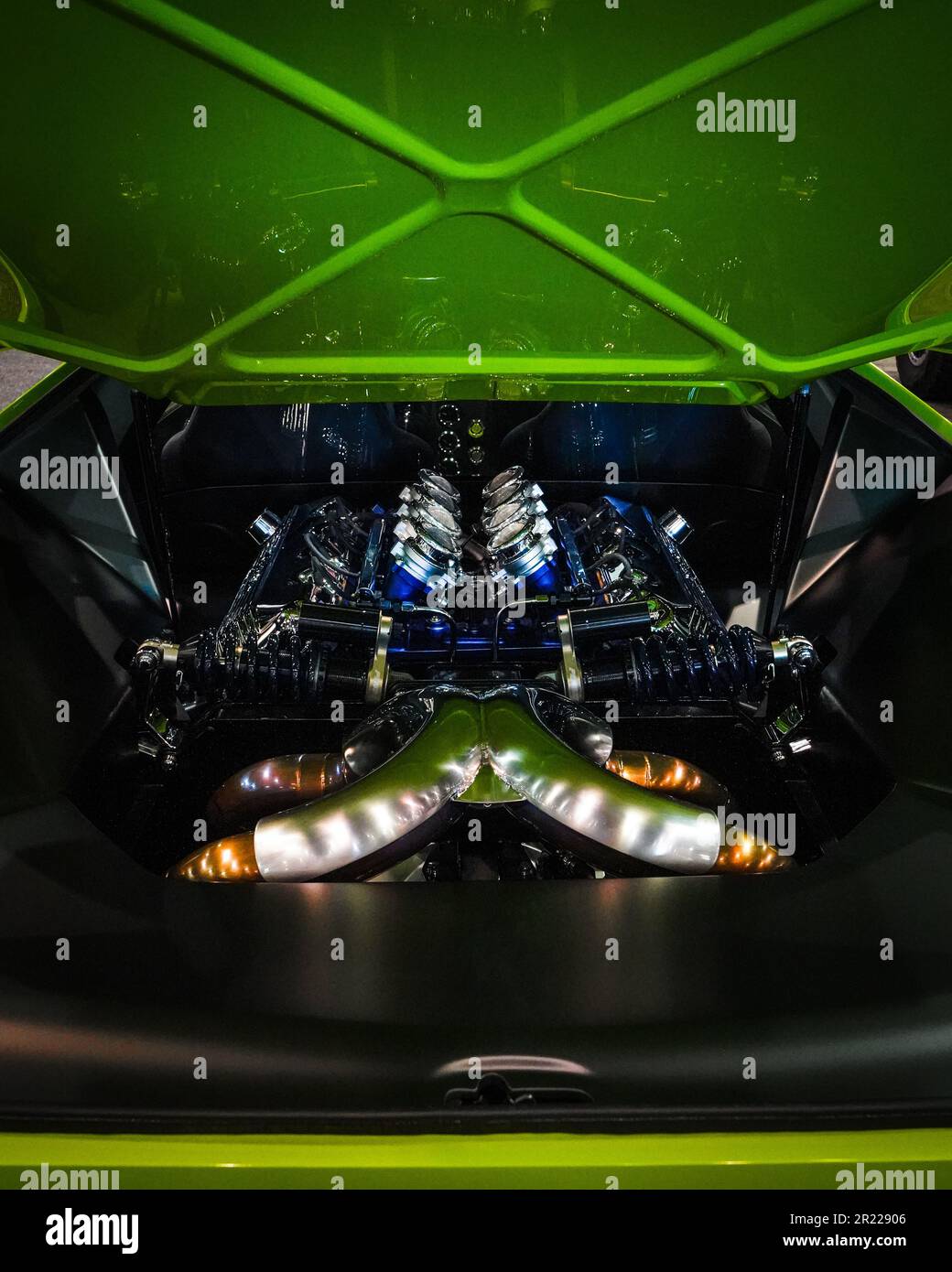 A close-up view of the engine compartment of a car, illuminated by the ...