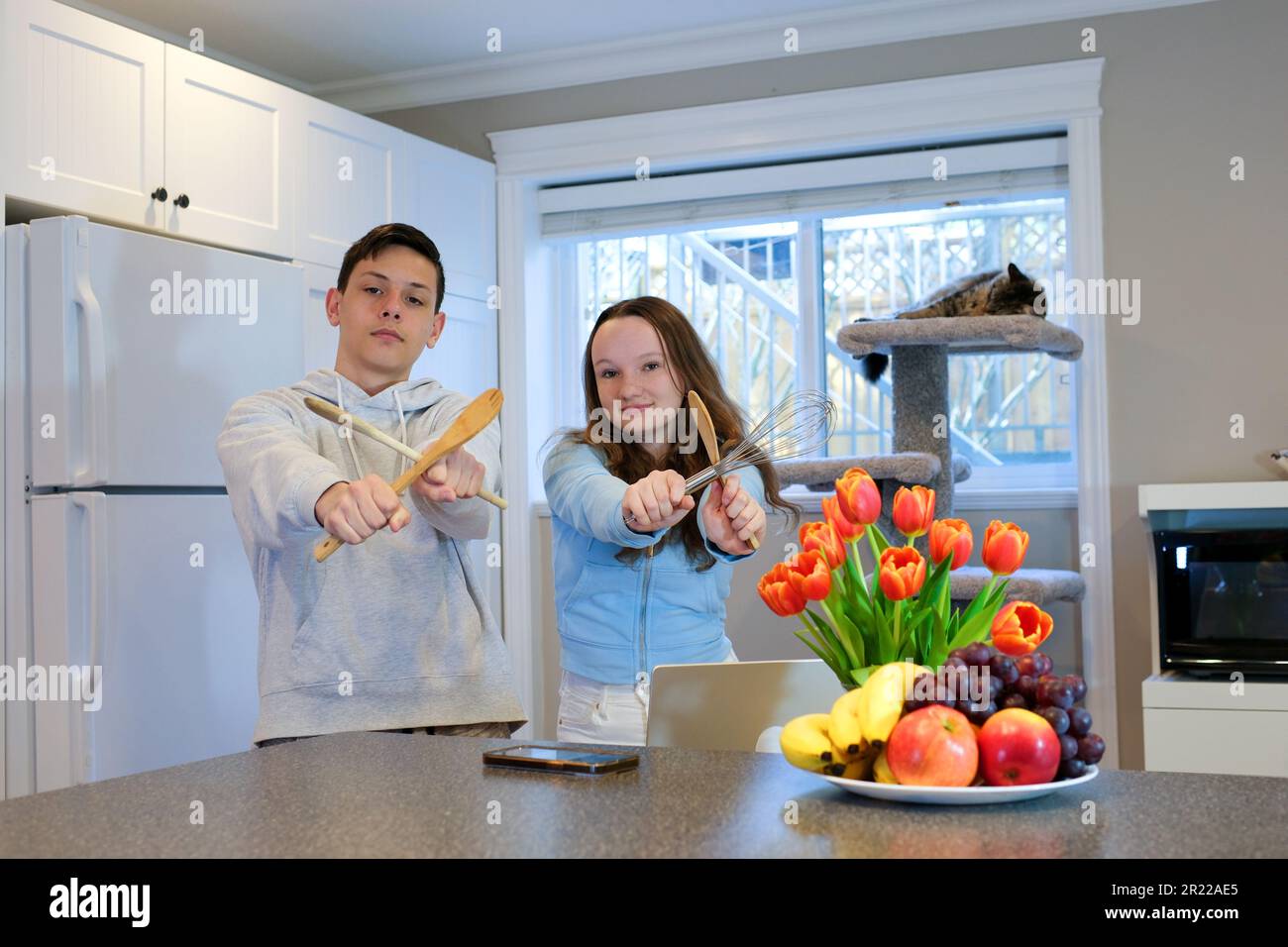 boy and girl in kitchen playing fighting dancing having fun spending ...