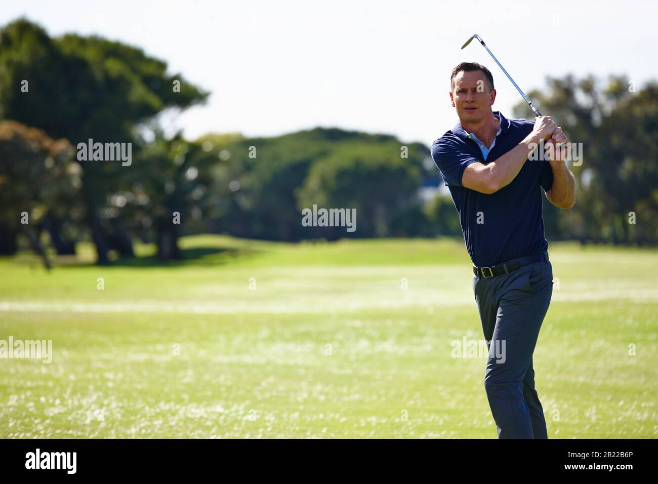 Focused on his follow through. a handsome mature man playing a game of ...