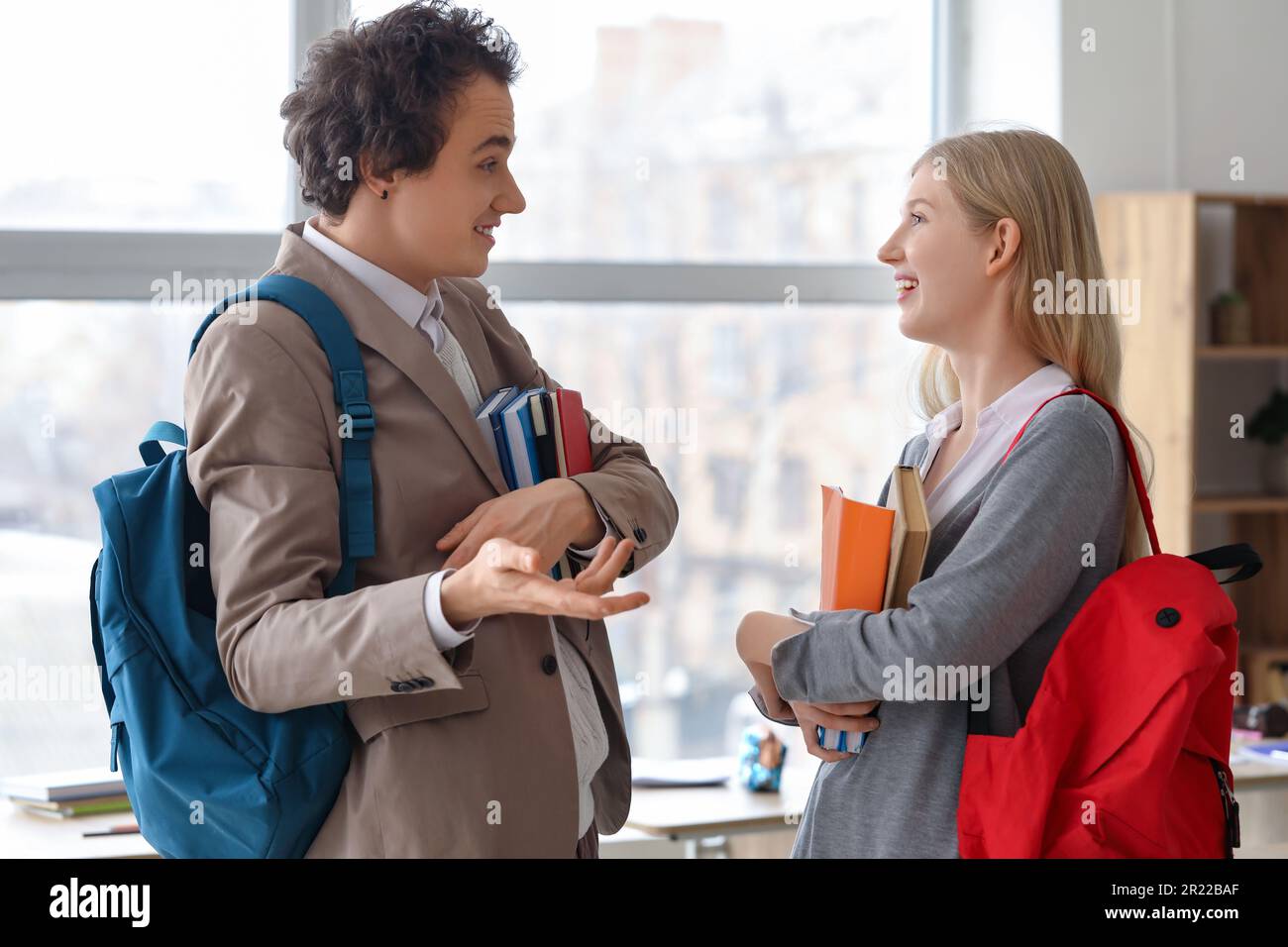 Cute teenage couple with books in classroom Stock Photo - Alamy