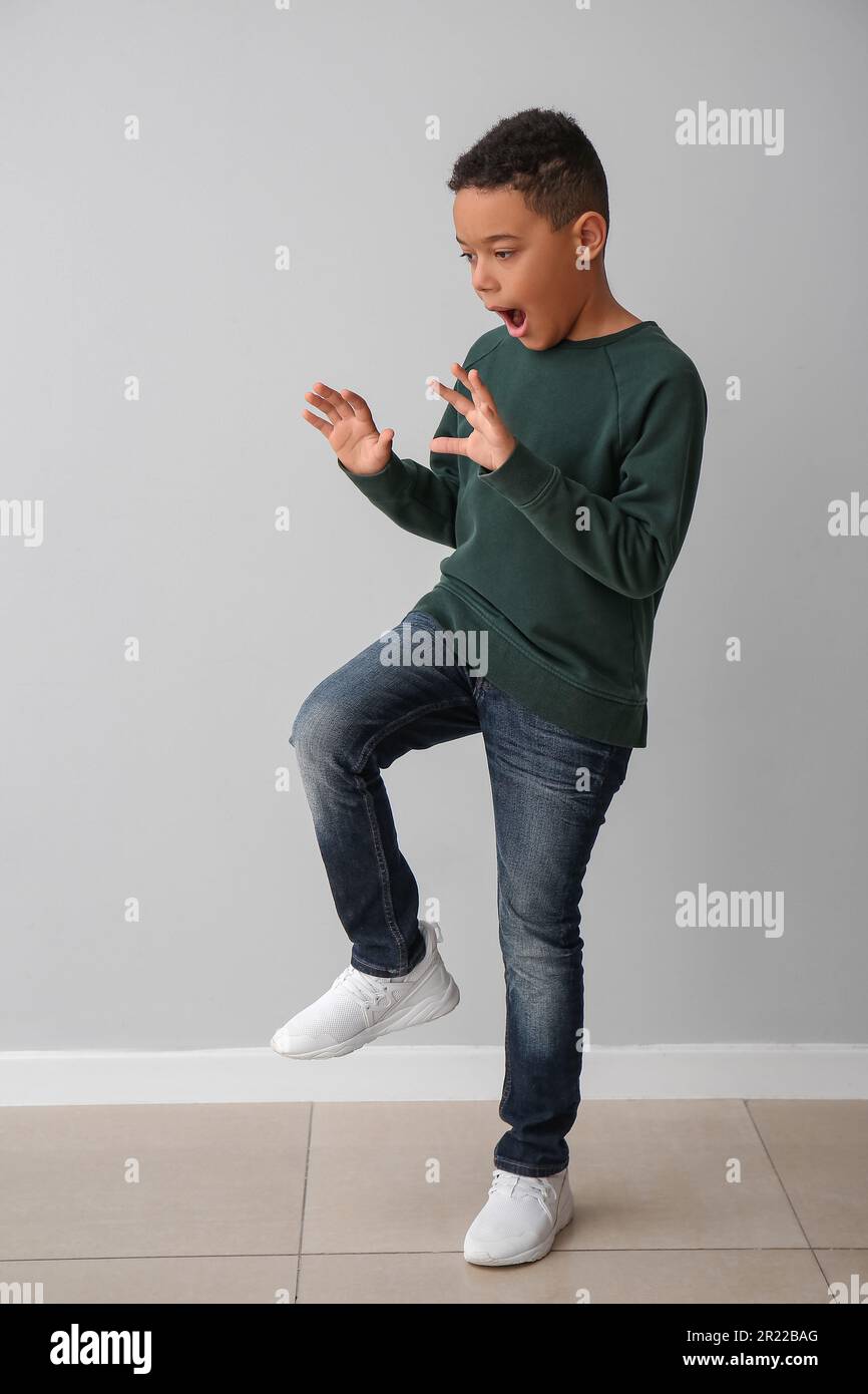 Scared little African-American boy on light background Stock Photo - Alamy