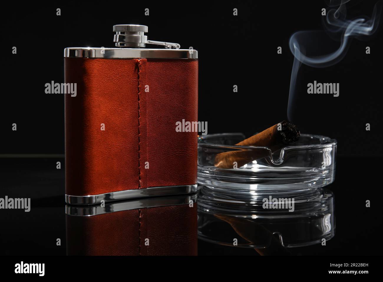 New hip flask and ash tray with cigar on black background Stock Photo ...