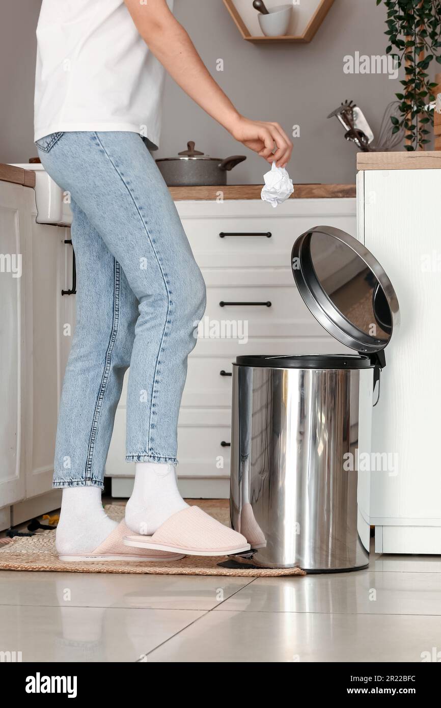 Woman opening trash bin with her foot in modern kitchen Stock Photo - Alamy