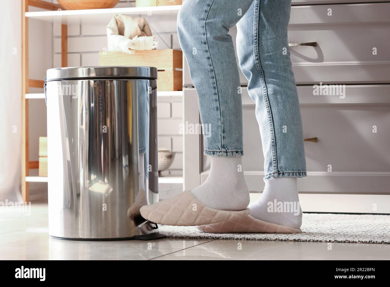 Woman opening trash bin with her foot in modern kitchen Stock Photo - Alamy