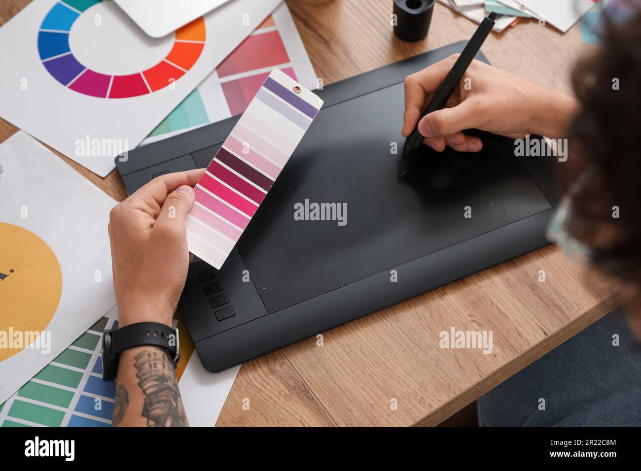 Male graphic designer working with tablet and color palette in office ...