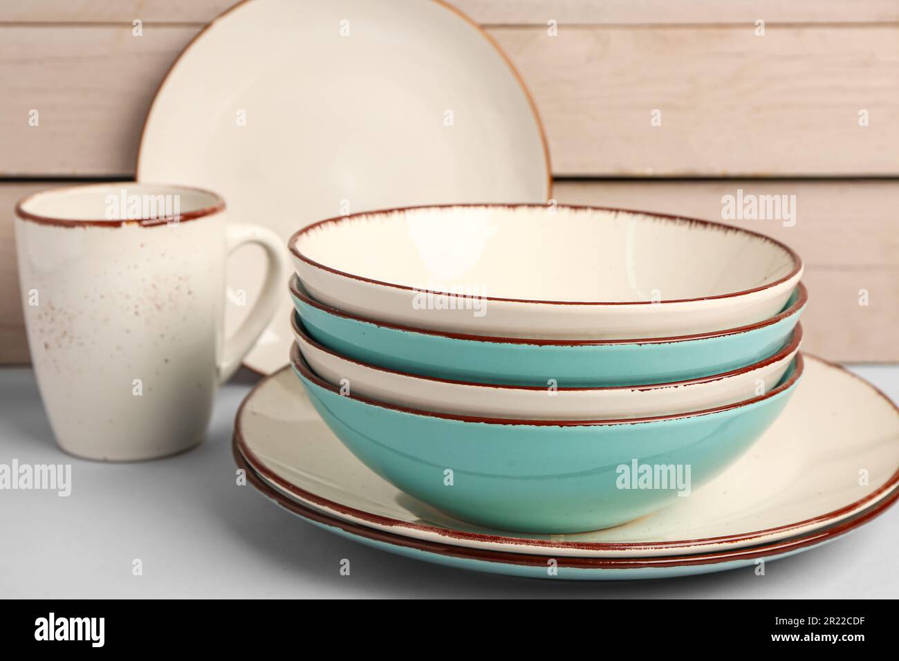 Set of different dishes on table near white wooden wall Stock Photo - Alamy