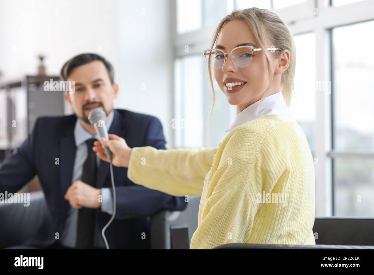 Female journalist with microphone having an interview with man in ...