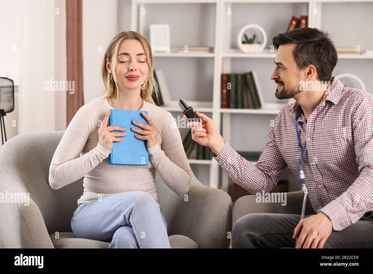 Male journalist with microphone having an interview with woman in ...