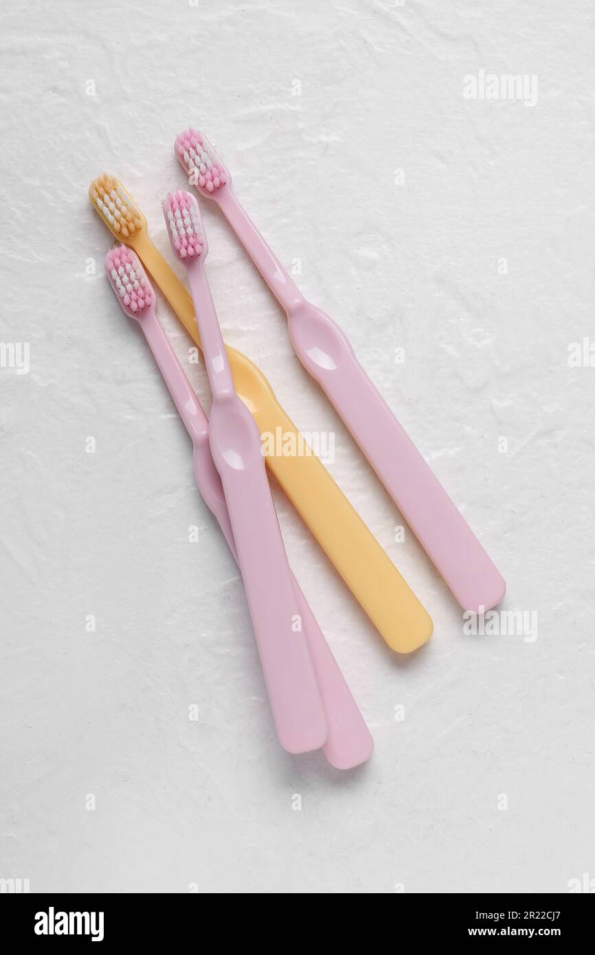 Plastic toothbrushes on white textured background Stock Photo - Alamy