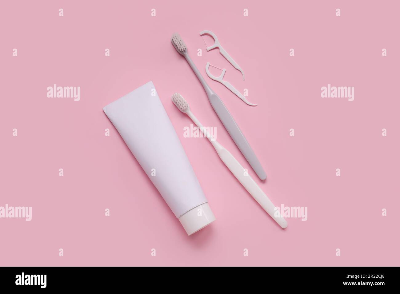 Plastic toothbrushes, toothpicks and paste on pink background Stock ...