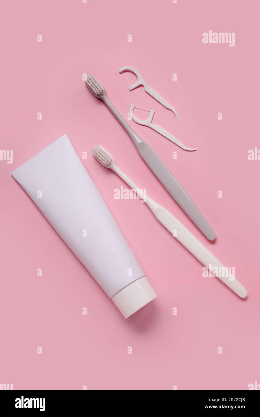 Plastic toothbrushes, toothpicks and paste on pink background Stock ...