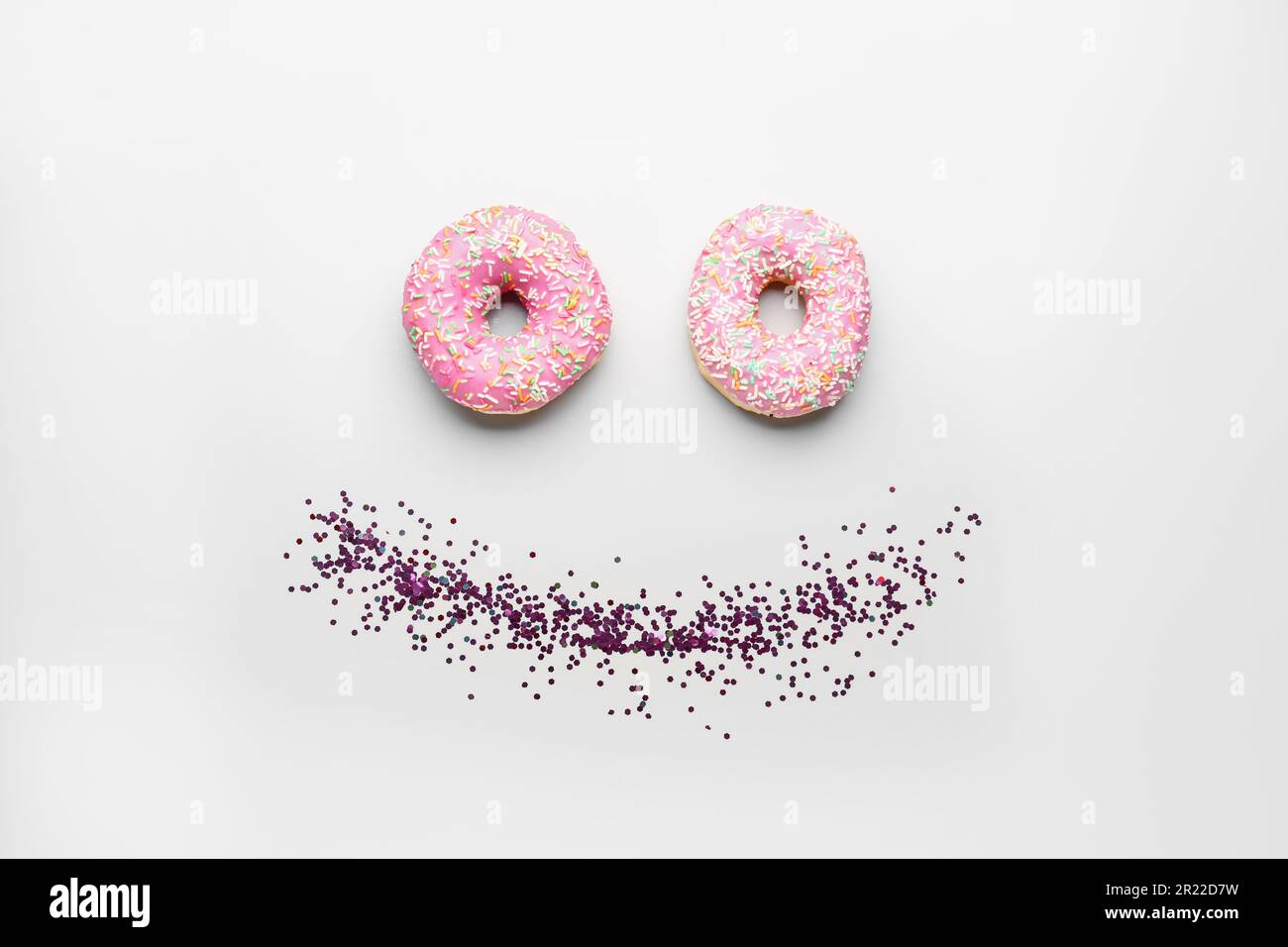 Smile made of donuts with confetti on white background Stock Photo - Alamy