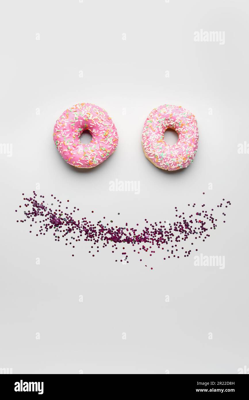 Smile made of donuts with confetti on white background Stock Photo - Alamy