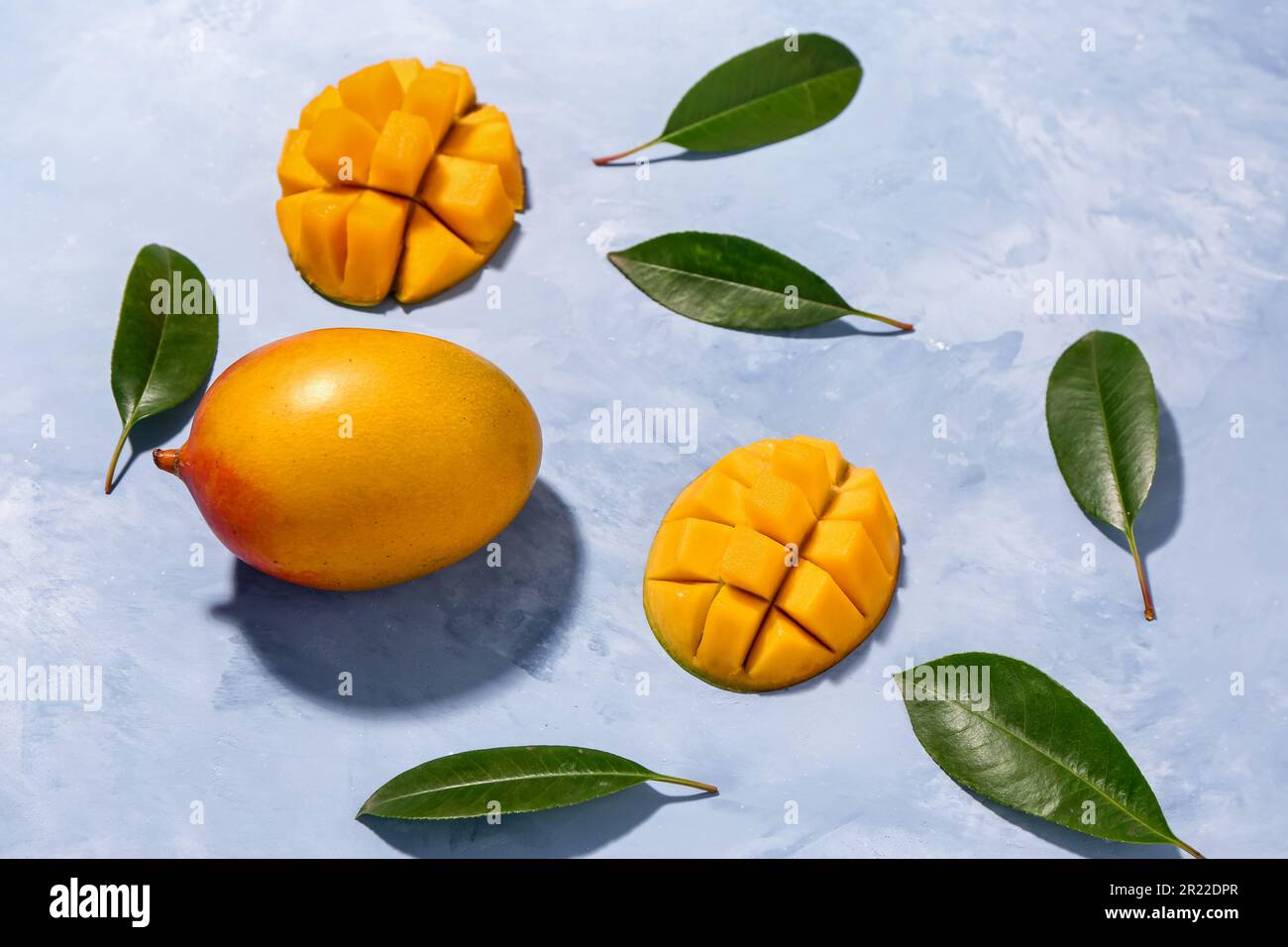 Fresh ripe mangoes on light blue background Stock Photo - Alamy