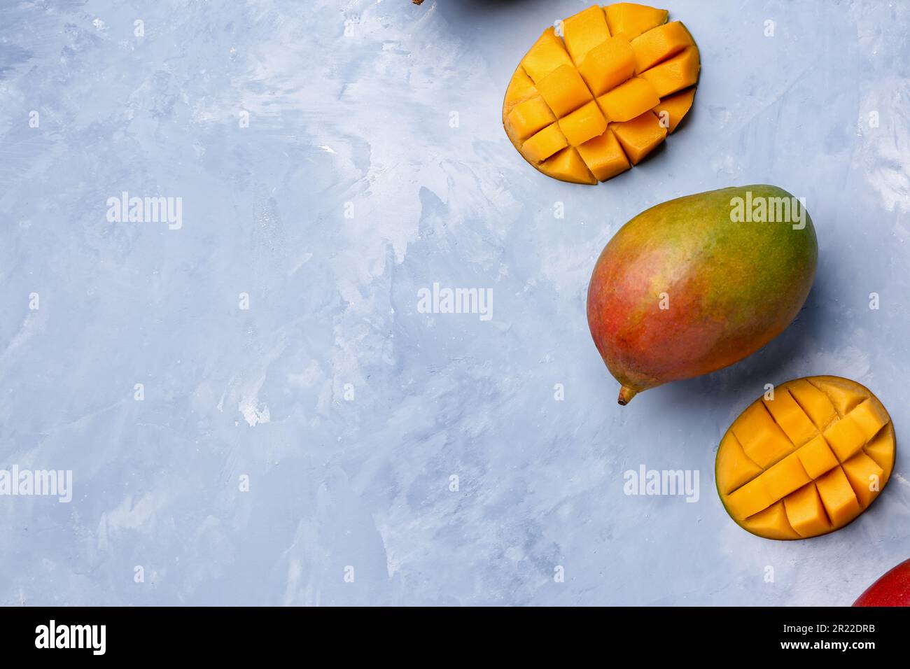 Fresh ripe mangoes on light blue background Stock Photo - Alamy
