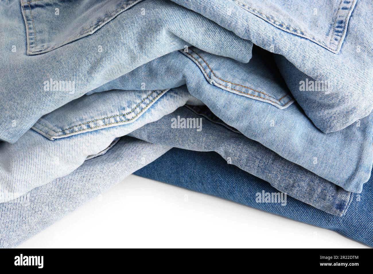 Different folded denim jeans on white background Stock Photo - Alamy