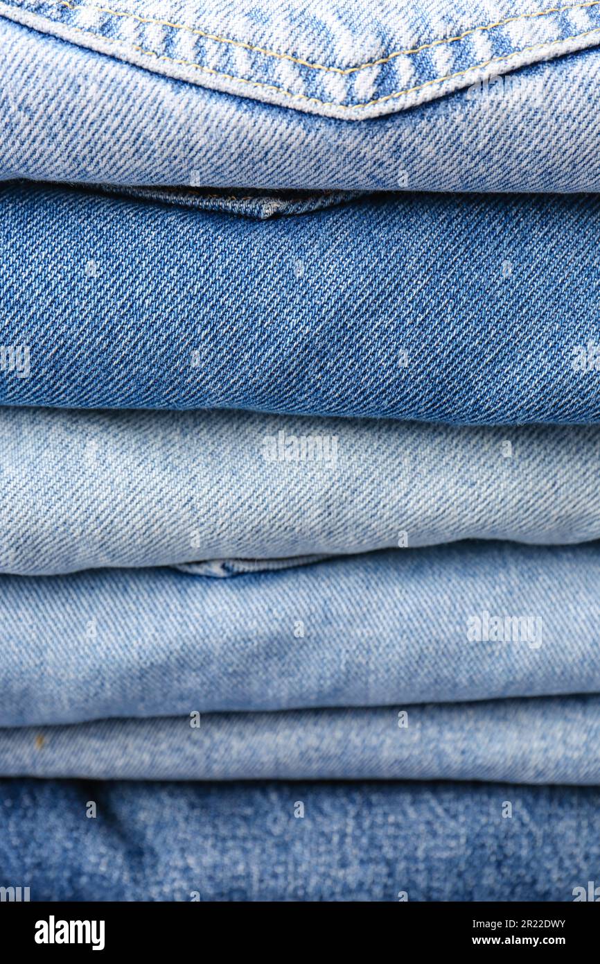 Different folded denim jeans as background, closeup Stock Photo - Alamy