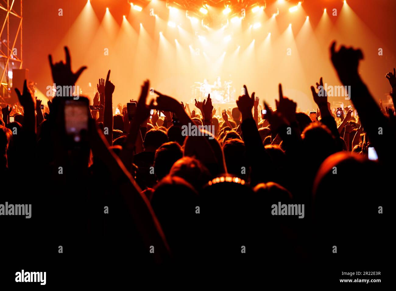 People with raised hands at a music concert. Fans in a concert hall ...