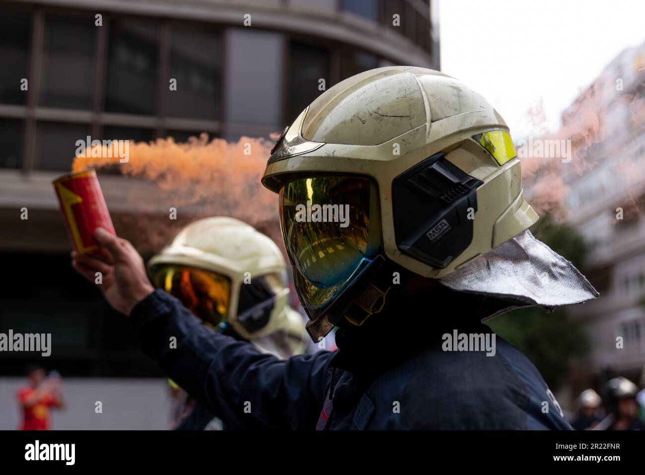 Madrid, Spain. 16th May, 2023. A firefighter holds a red smoke flare ...