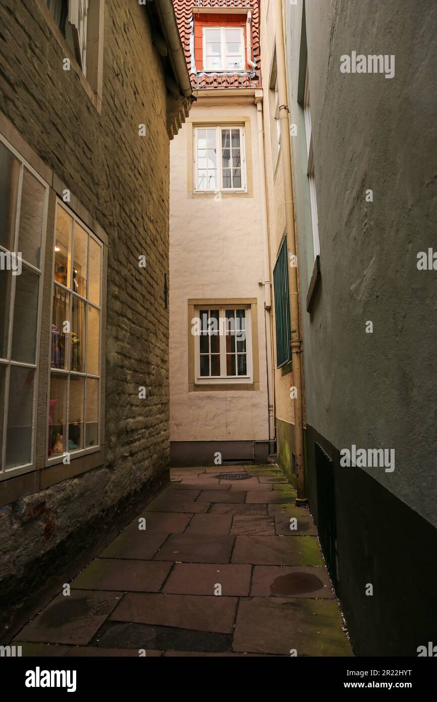 A vertical shot of a stone alley through old buildings Stock Photo - Alamy