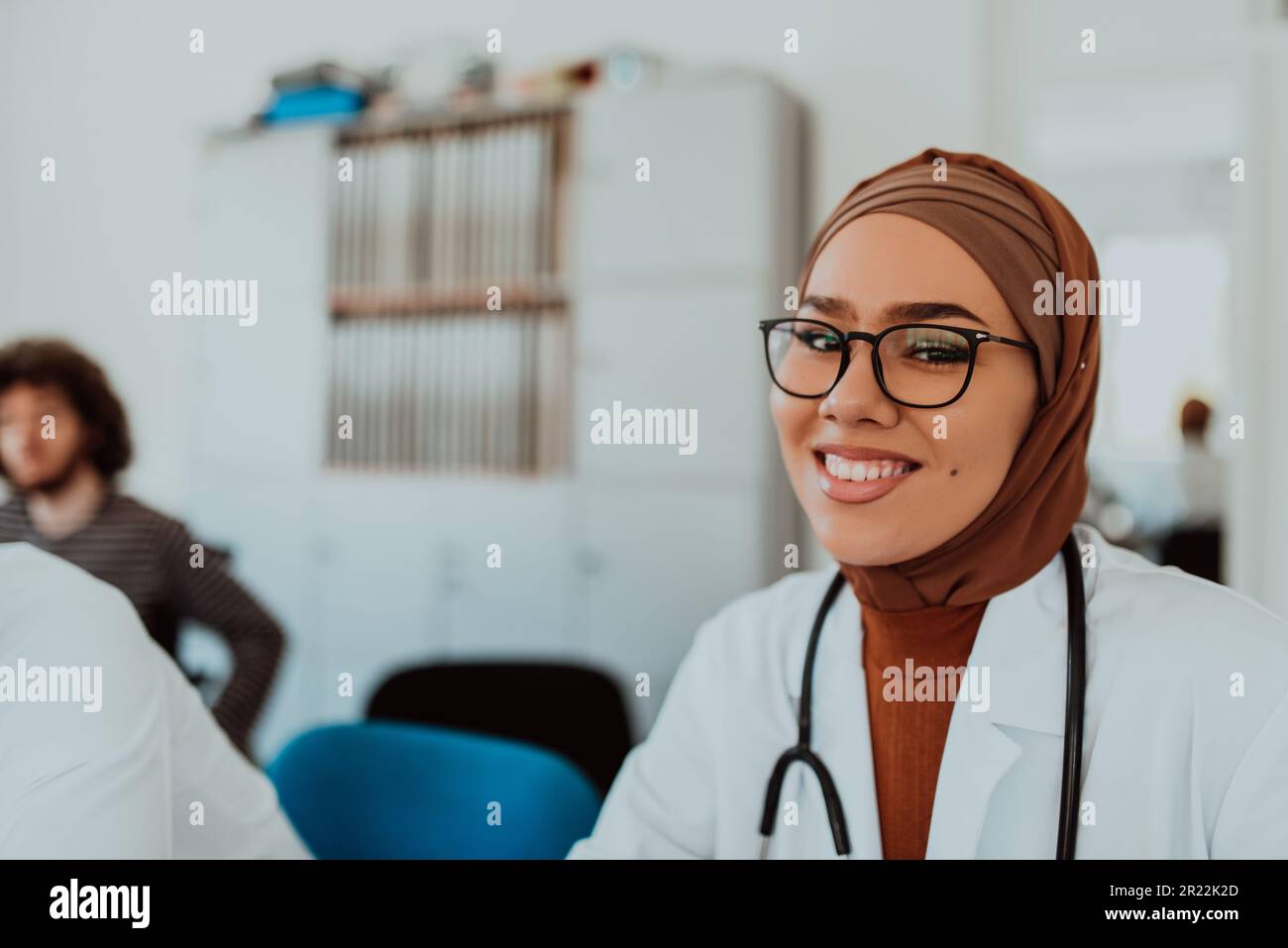 In a modern meeting room, a Muslim female doctor wearing a hijab ...