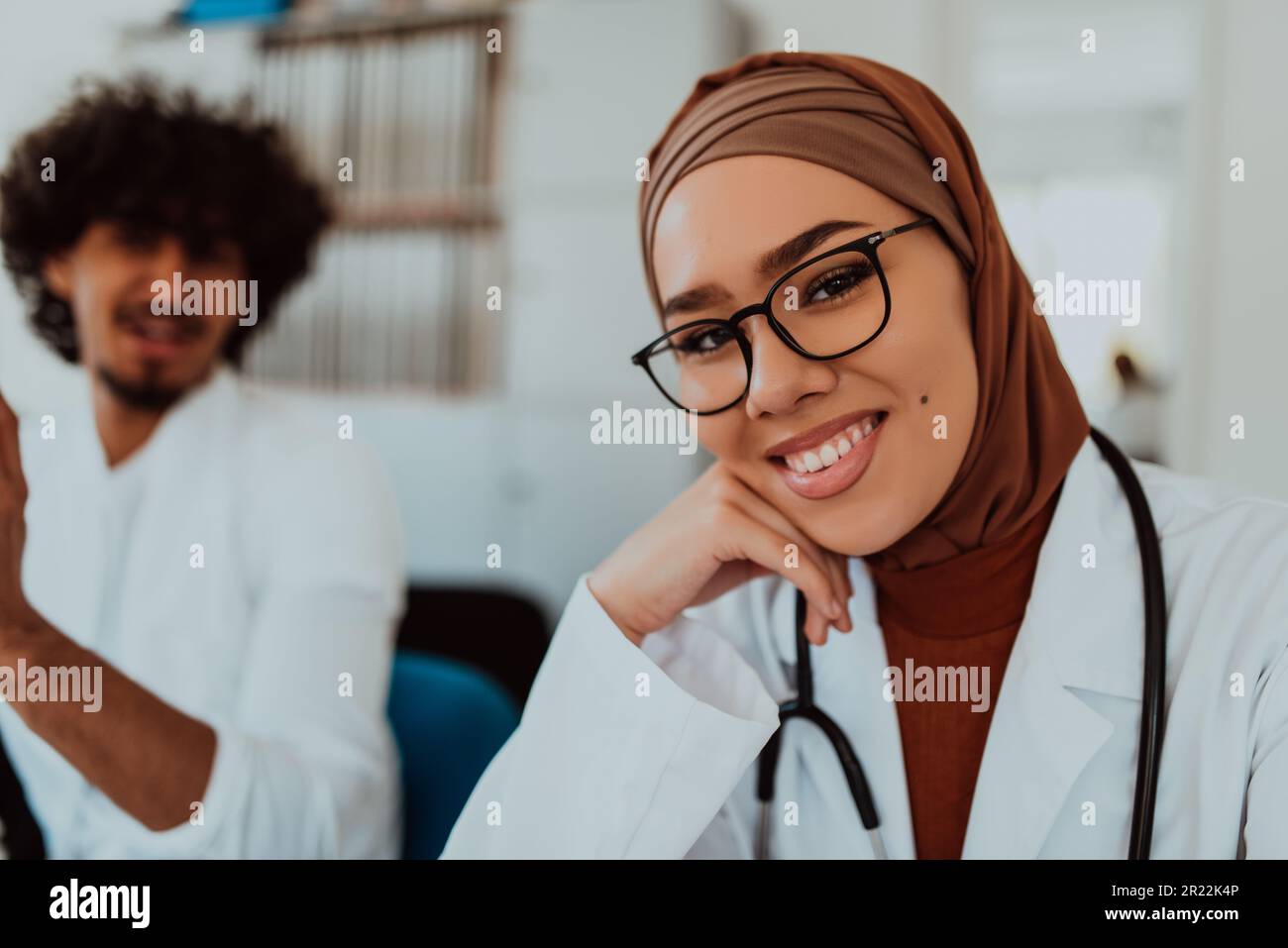 In a modern meeting room, a Muslim female doctor wearing a hijab ...