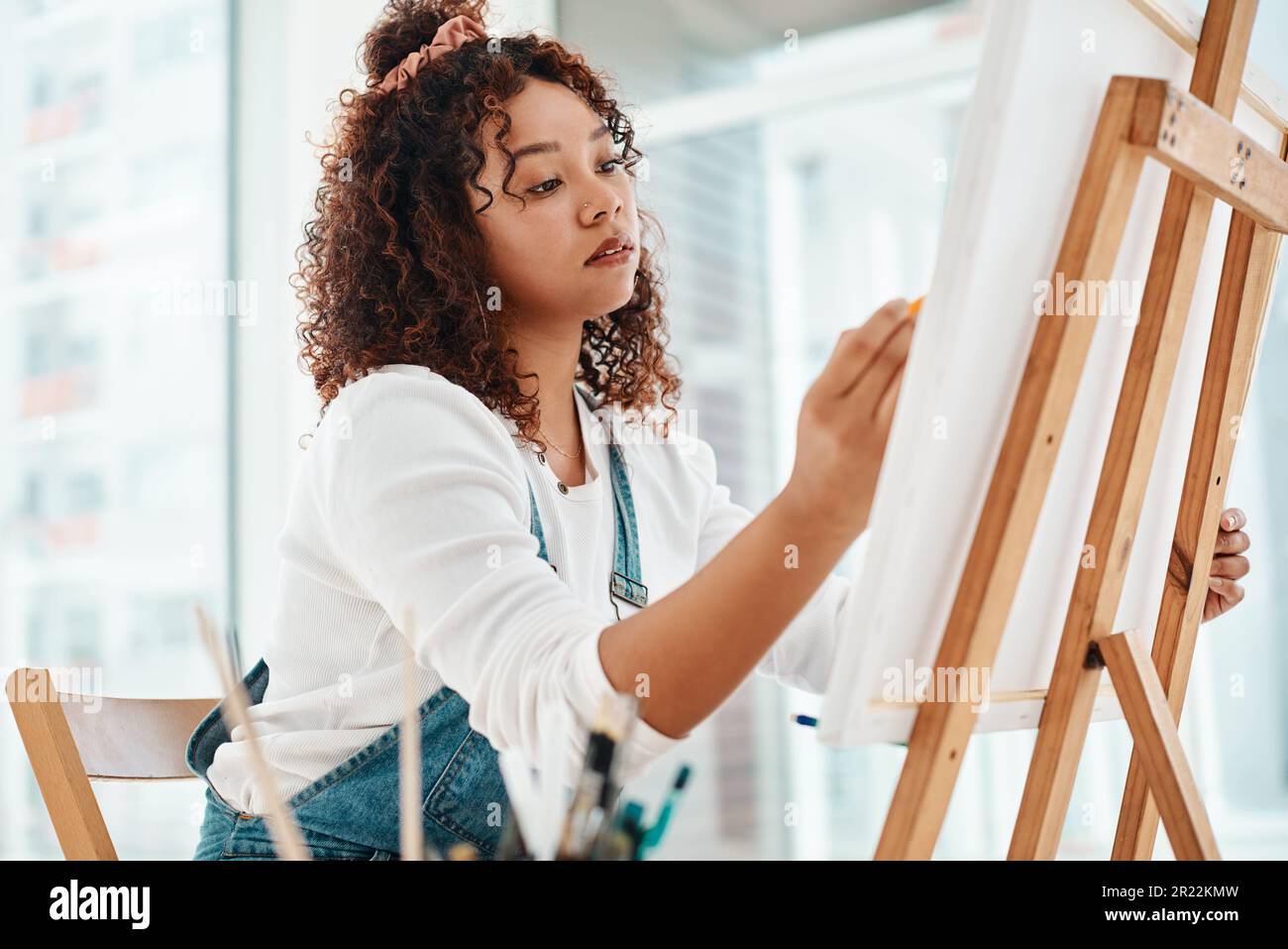 Creativity never runs dry here. an attractive young artist sitting ...