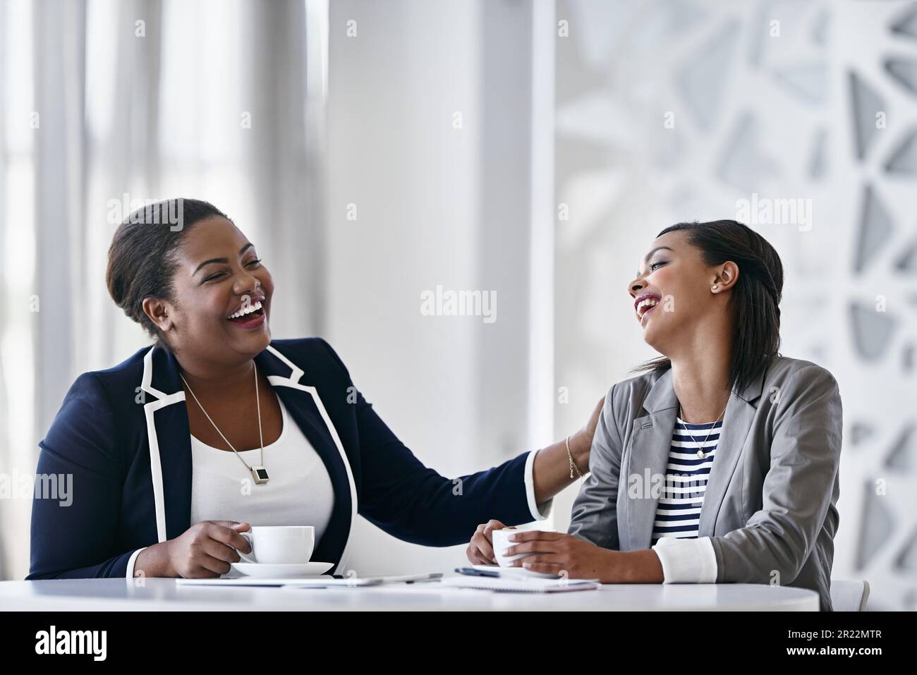 Laughter In The Workplace Two Coworkers Laughing Together While